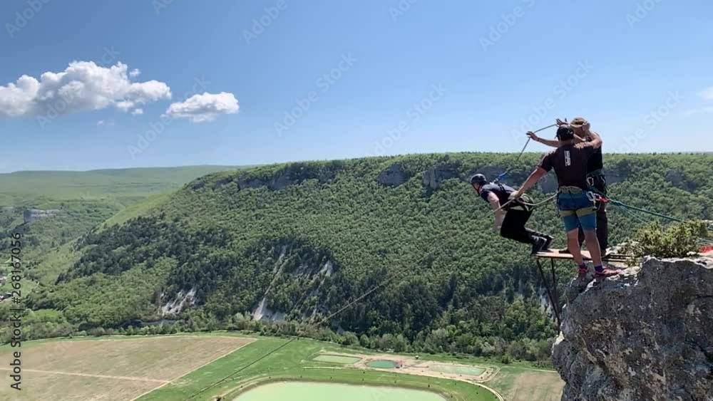 Rope jumping. A man jumps with a rope from a cliff. A beautiful flight ...