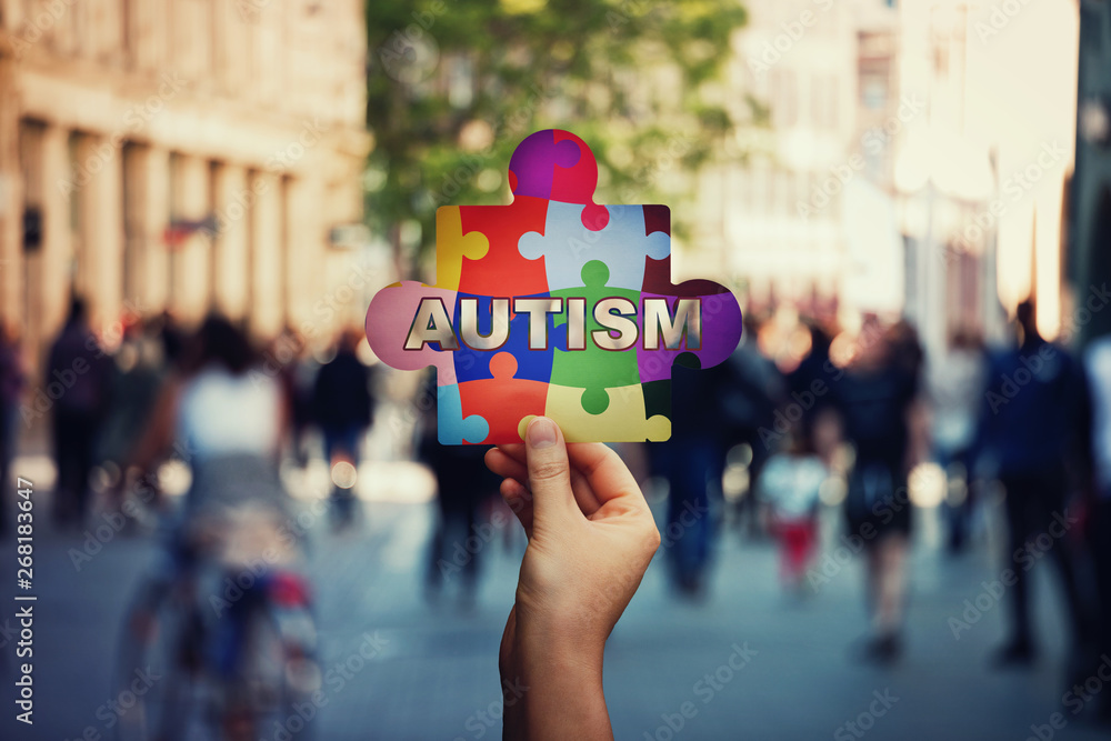 symbol of Autism as a child hand holding a colorful puzzle piece over a ...