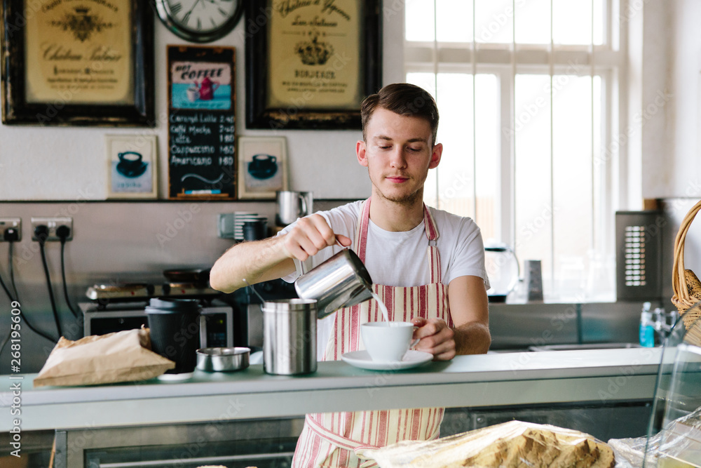 Young man making coffee in a small bakery business Stock Photo | Adobe ...