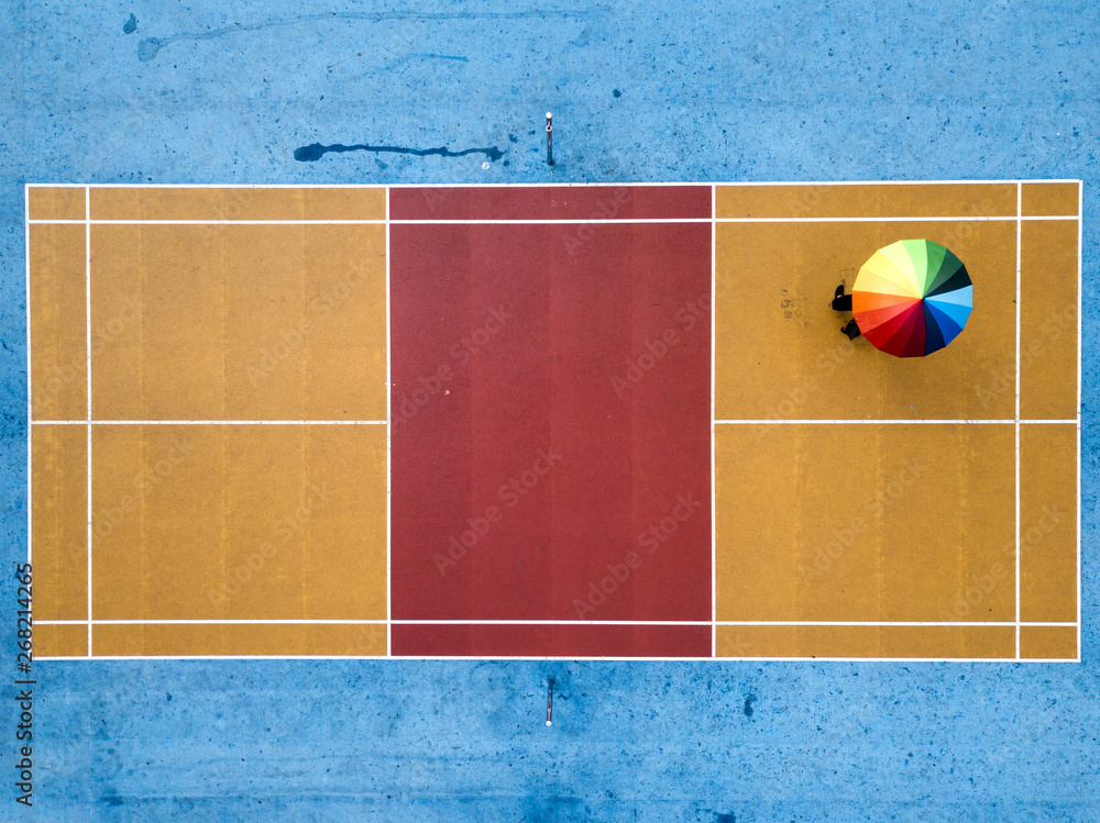 Overhead view of person with colorful umbrella on volleyball court ...