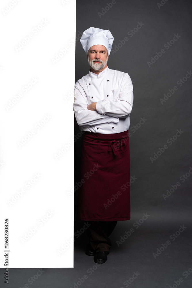 Full length portrait of a happy chef cook showing copyspace on the ...