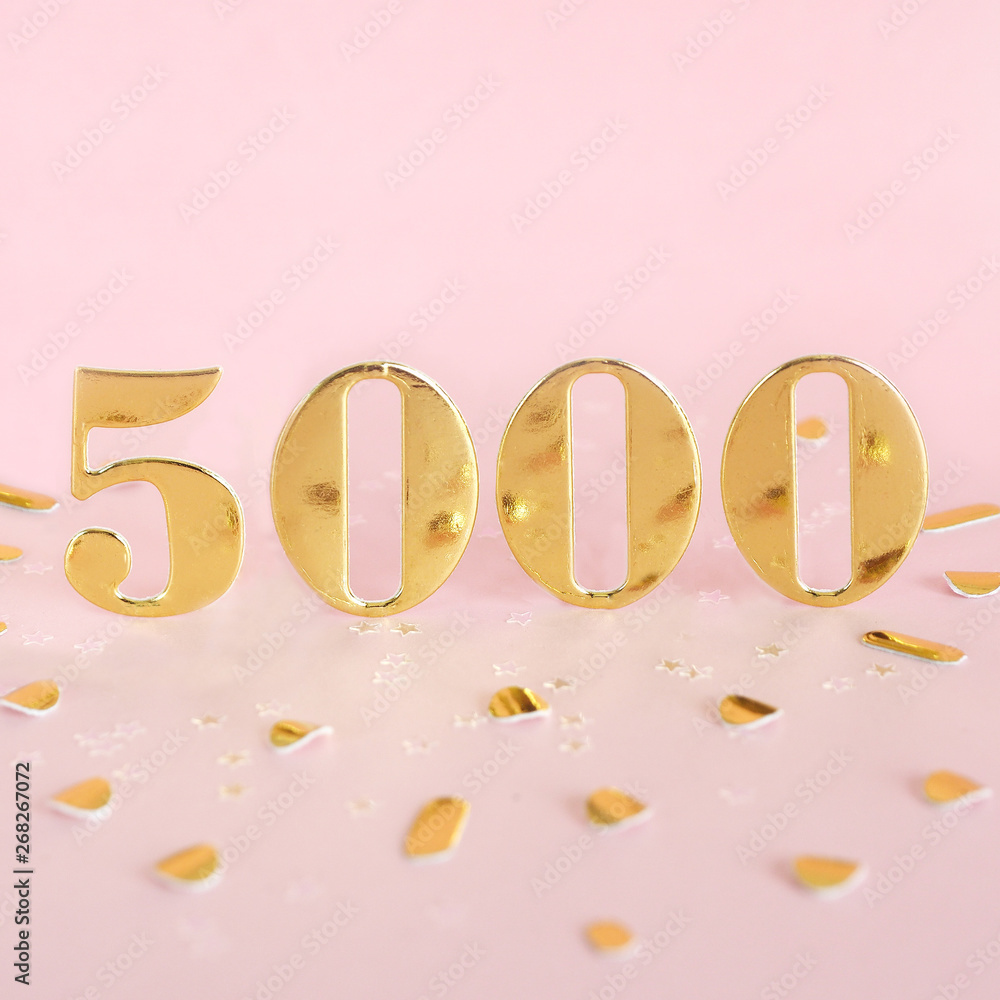 The number 5000 in golden numbers on a pink background and golden ...