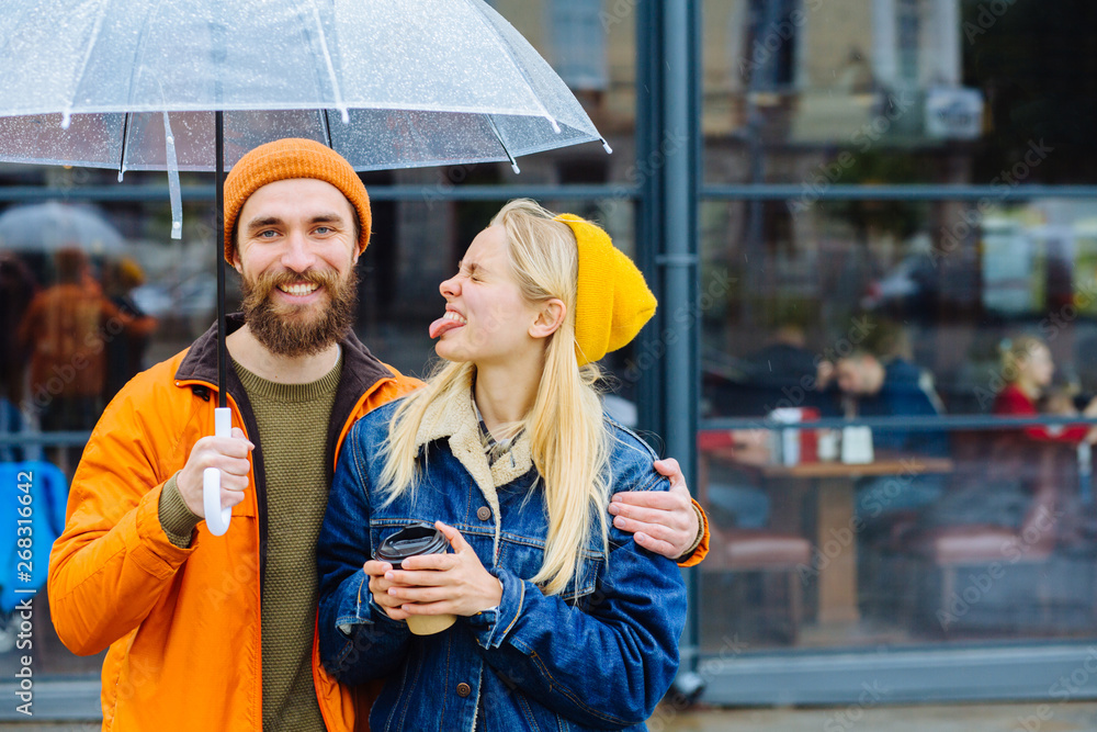 Joyful hipster girl showing tongue making boyfriend laugh, joking ...