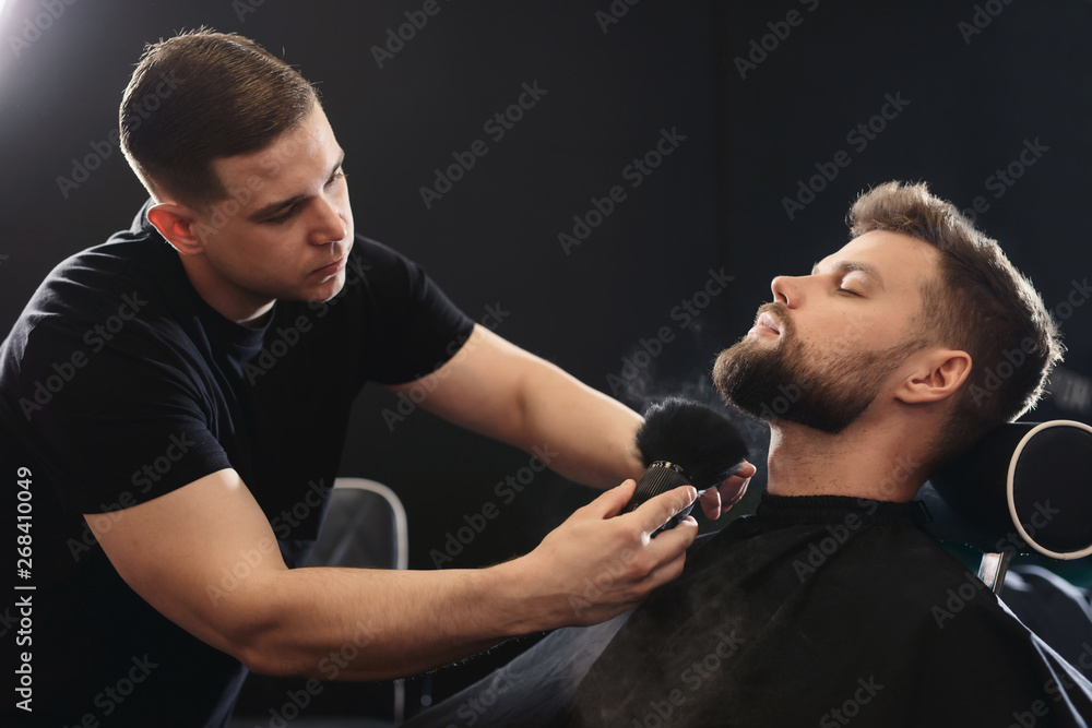 Getting perfect shape. Close-up side view of young bearded man getting ...