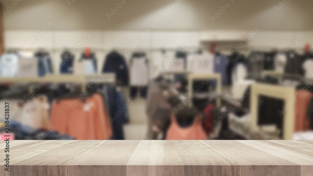 Empty wood table and blurred clothing store, product display montage ...