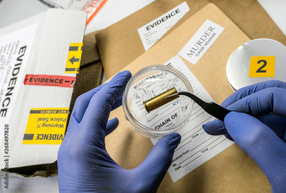 Scientific police examining a bullet cap in ballistic Laboratory ...