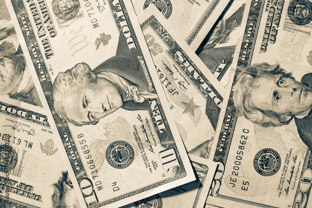 Dollar bills of various denominations laid on each other. Background ...