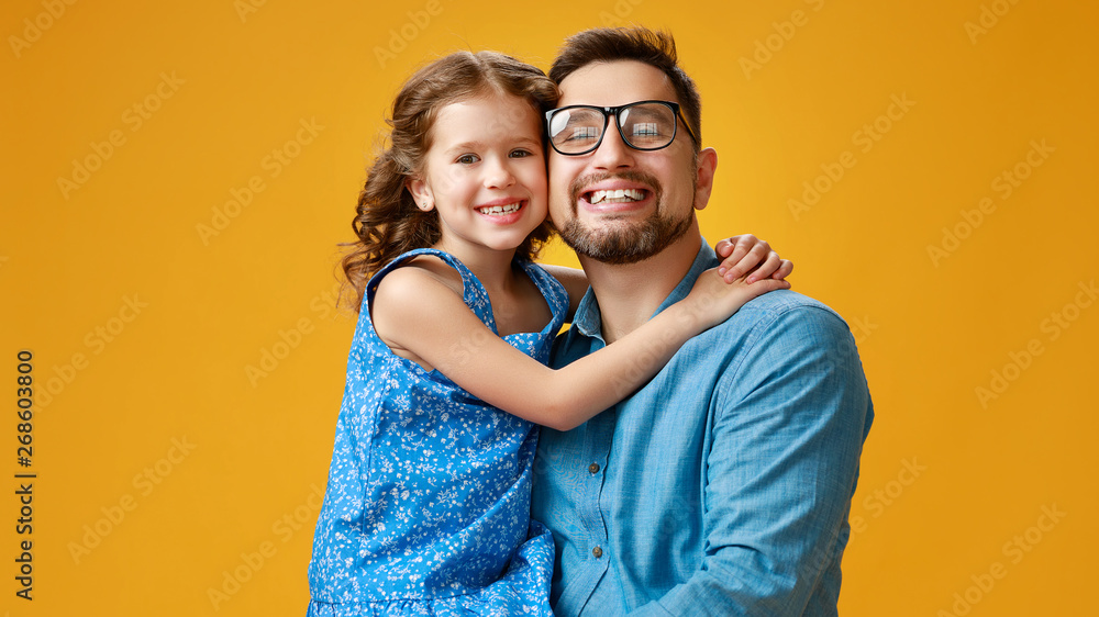 happy father's day! cute dad and daughter hugging on yellow background ...