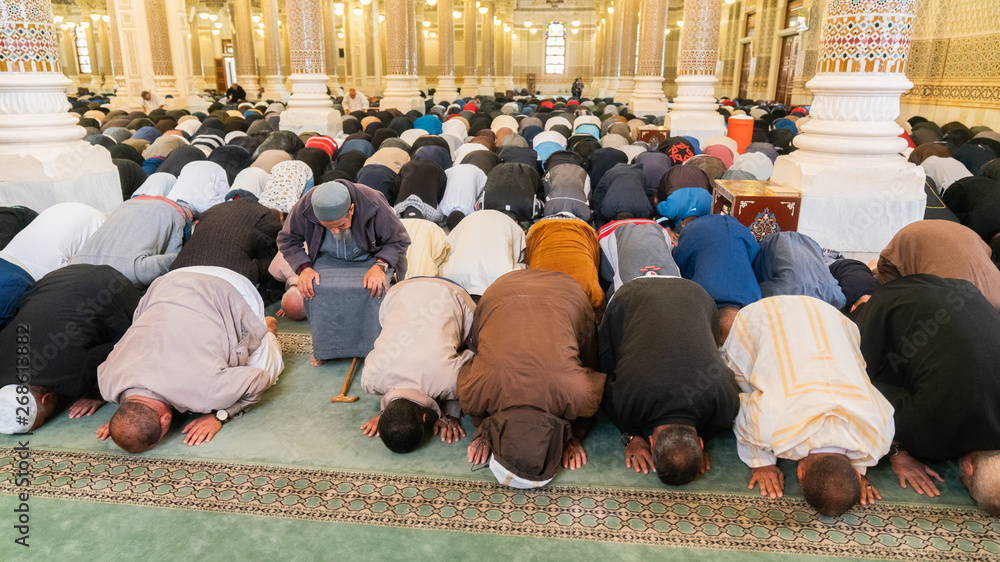 Muslim men bowing, kneeling and praying inside of a big mosque in ...