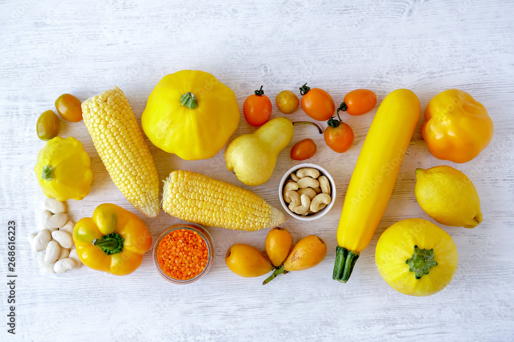 Assorted types of yellow food- vegetables, fruits, legume on white ...