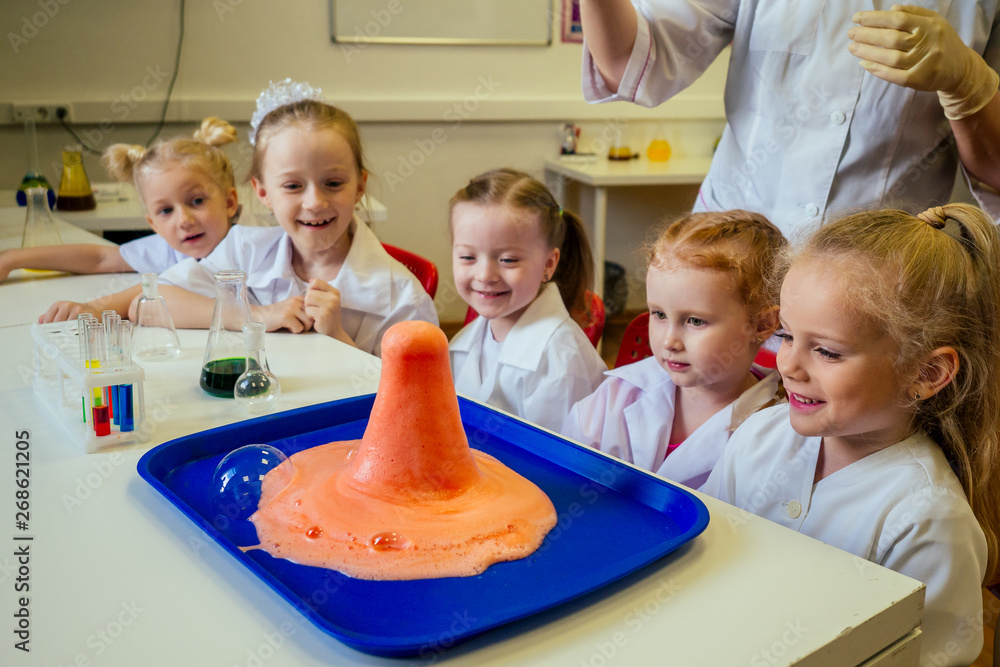 group of school girl kids with teacher in school laboratory making ...