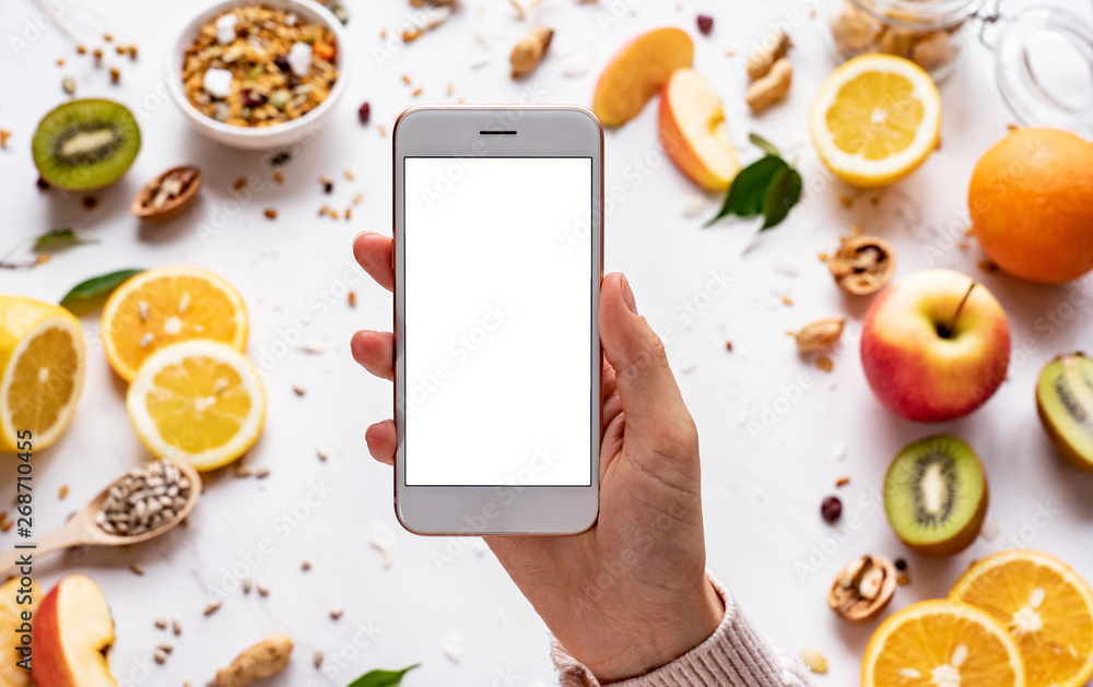 Female hands holding smartphone on healthy food background, woman using ...