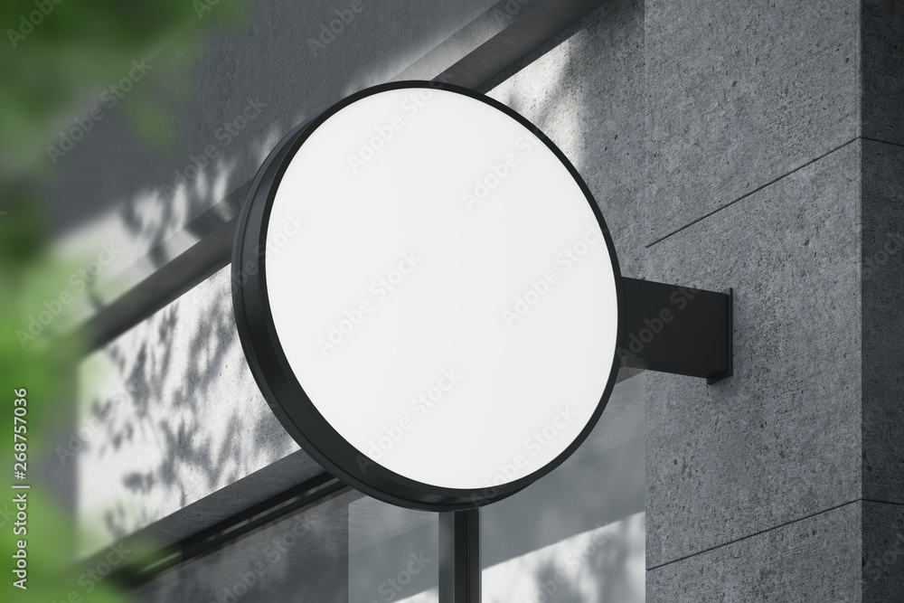 Luminous round white blank lightbox mounted on the wall of the store ...