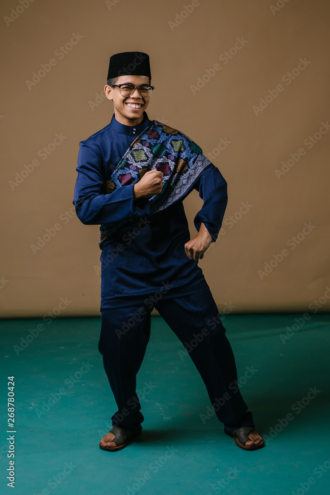 Studio portrait of a happy, handsome and young Malay Asian man in a ...