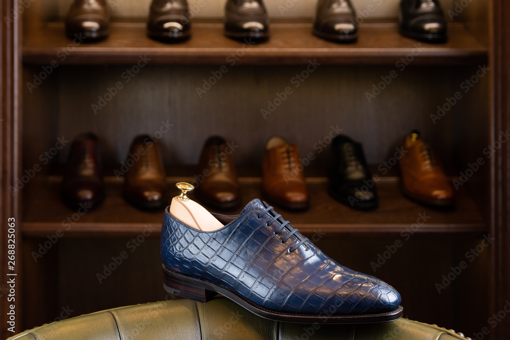 Blue full grain leather shoe in front of wooden display in men shoes ...