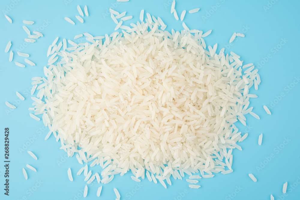 Pile white rice isolated on blue background on top view food object ...