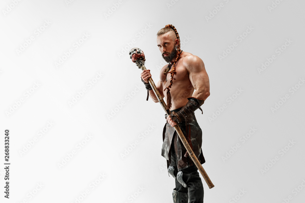 Serious long hair and muscular male model in leather viking's costume ...
