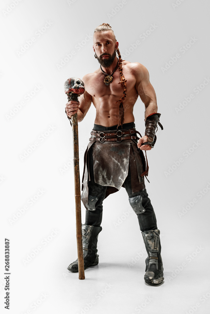 Serious long hair and muscular male model in leather viking's costume ...