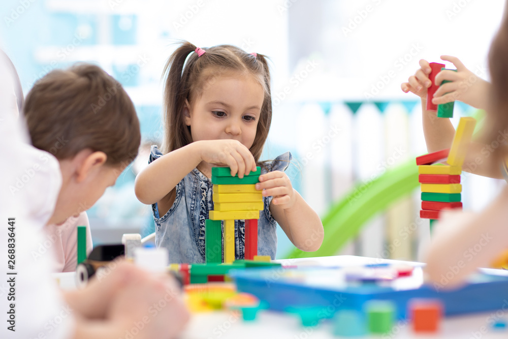 Little children build wooden toys at home or daycare. Emotional kids ...