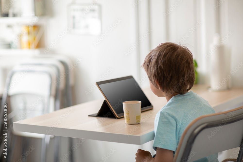 Boy watching stuff on his tablet Stock Photo | Adobe Stock