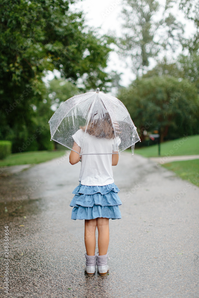 Cute young girl out walking in the rain with an umbrella Stock Photo ...