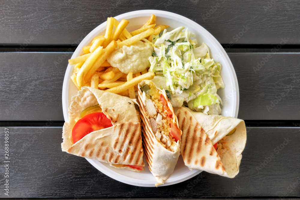 top down view of sliced chicken doner kebab sandwich on white plate in ...