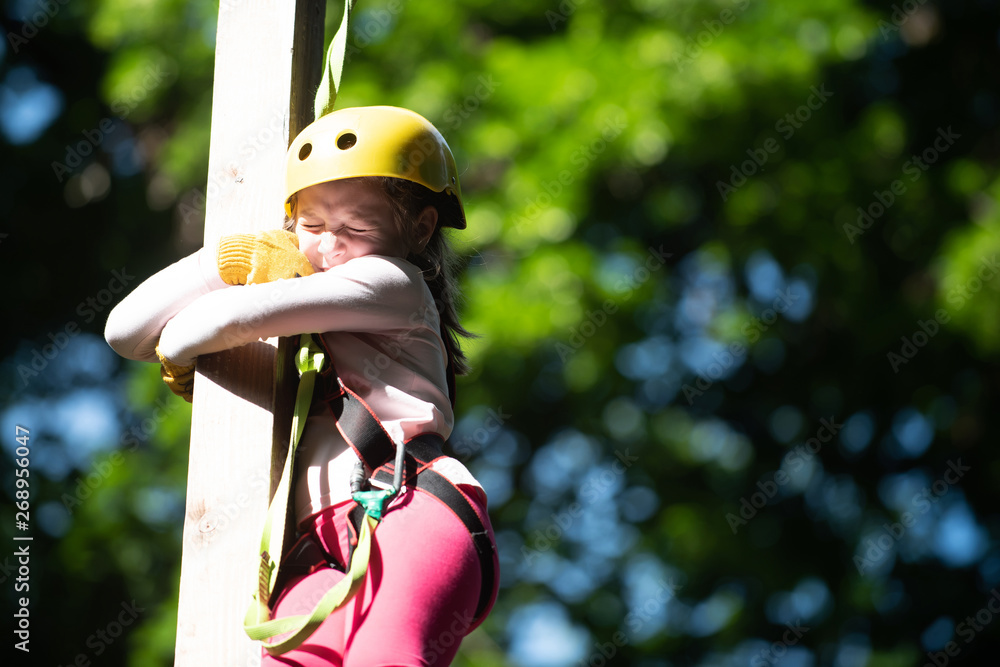 Rope way - little girl is looking at the rope slideway fearing. Little ...