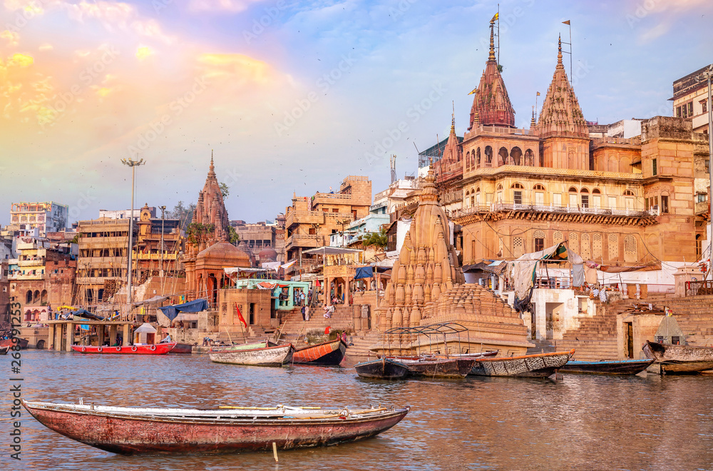 Póster Ancient Varanasi city architecture with view of wooden boat on ...