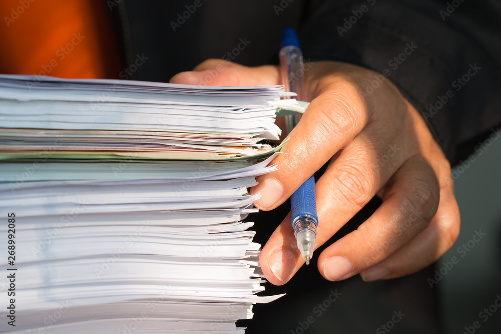 Business Documents concept : Employee man hands working in Stacks paper ...