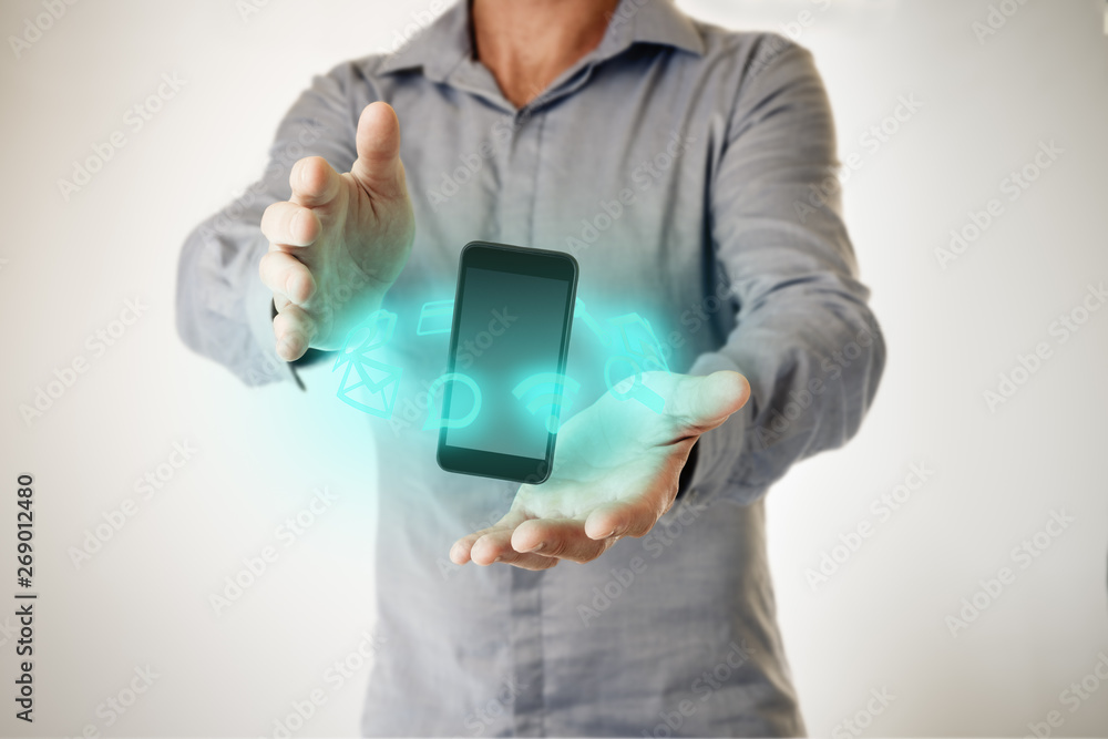 Man with phone floating between his hands and holographic digital icons ...