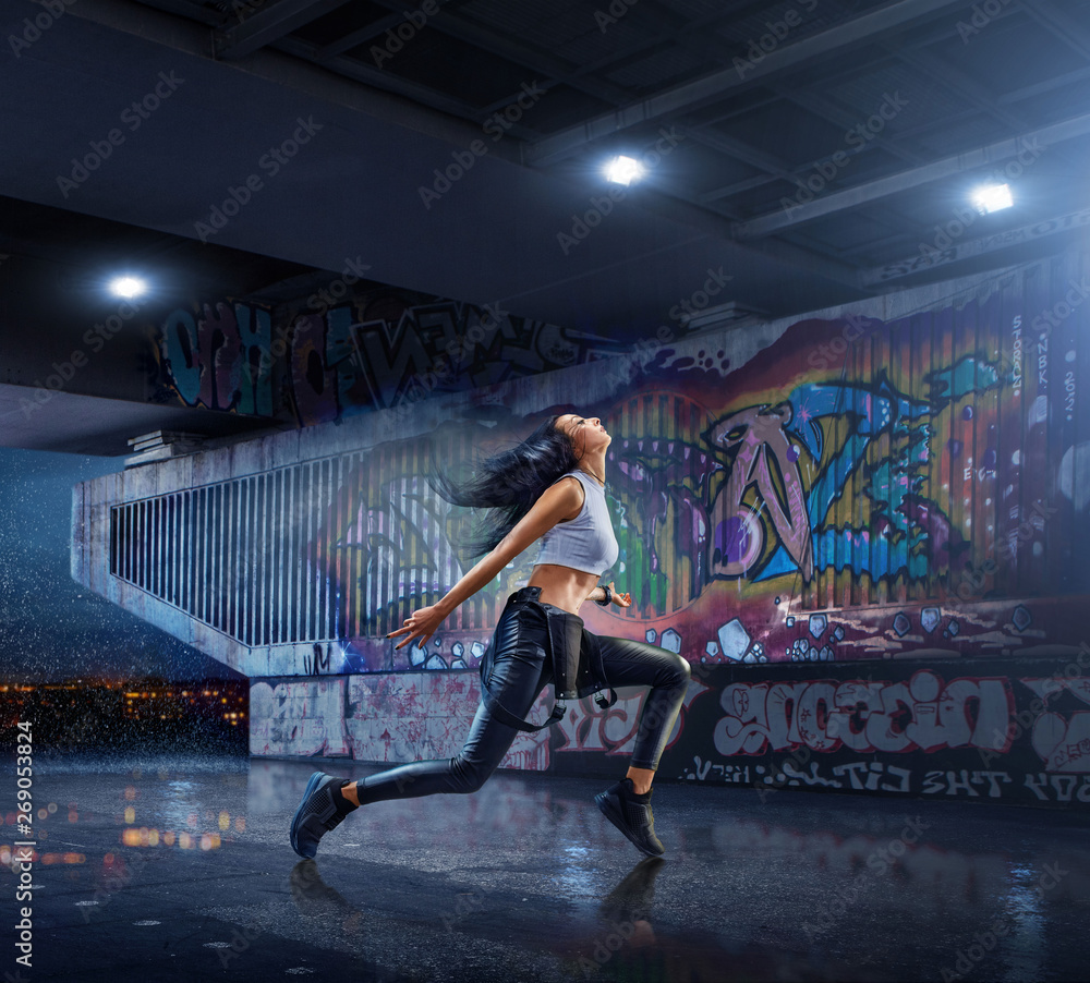 Female Hip Hop Dancer. Beautiful girl dancing at night on the background of graffiti wall Stock ...