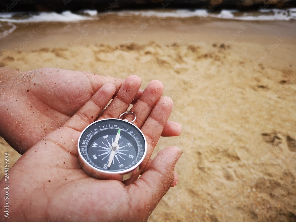 Holding a compass is an instrument used for navigation and orientation ...