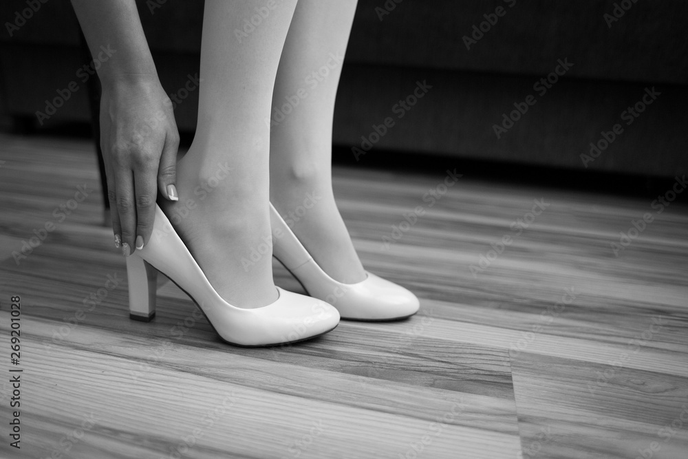 the girl wears a Shoe on the leg. Bride puts his shoes in the morning ...