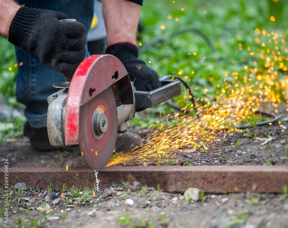 Hand of man with steel cutter tool on green background. Worker outside ...