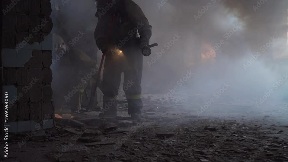 Fire protection.Firefighters move cautiously in a smoky building with a ...