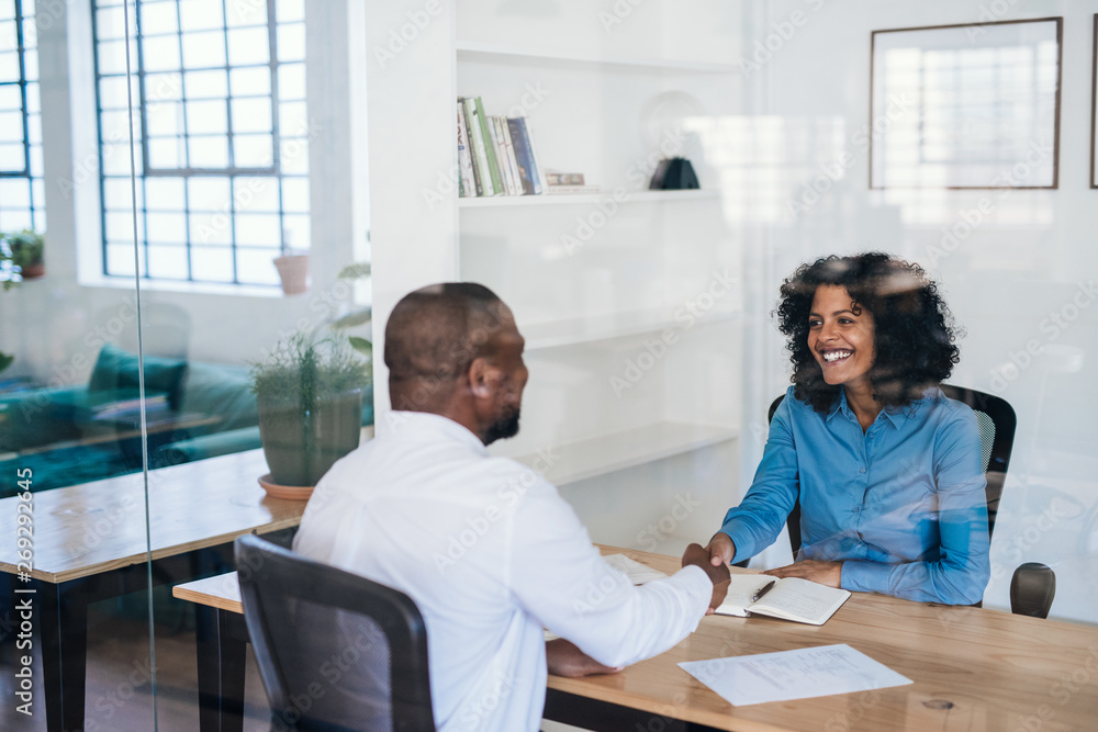Smiling manager shaking hands with a man after an interview Stock Photo ...