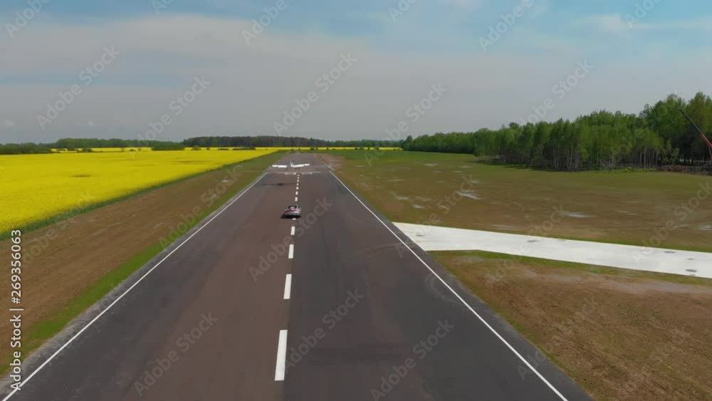 flying over propeller plane aircraft and sport car compete at speeds at ...