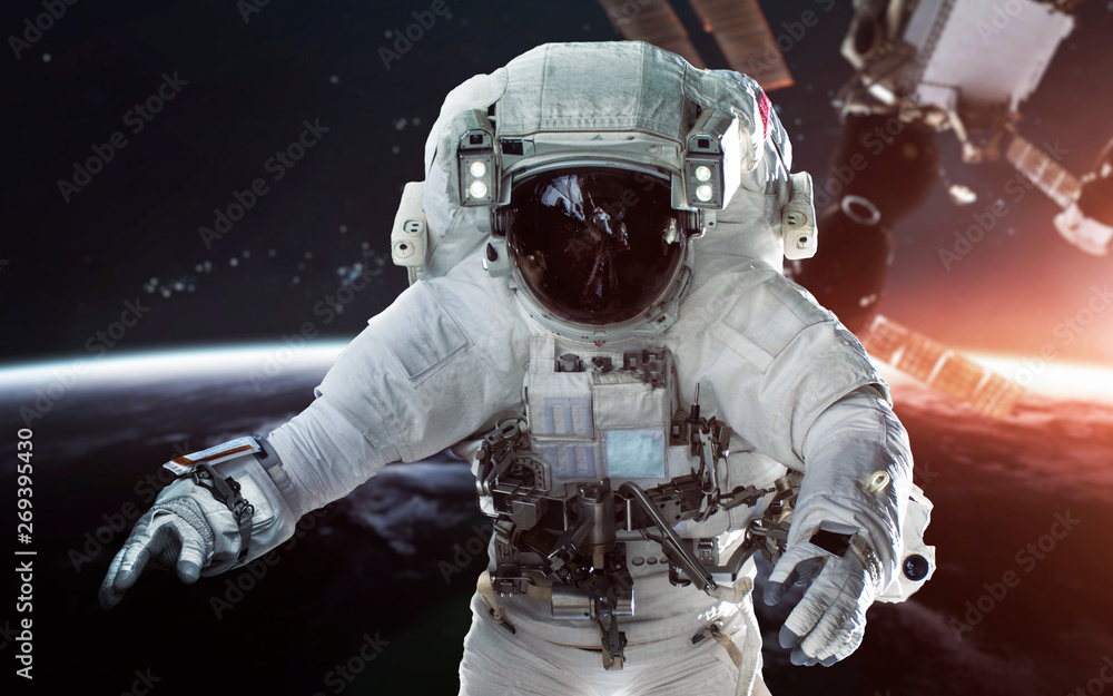 Astronaut at the Earth orbit with the Space station behind. Elements of ...