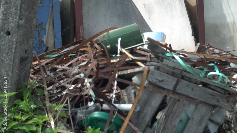 Dump site full of rusty metal trash and plastic waste behind a home ...