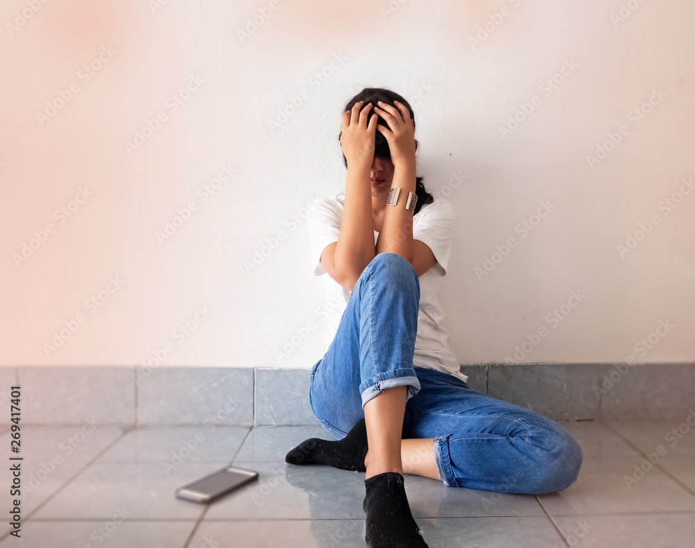 The stress woman sitting on ground floor,raise hand touch head and turn ...