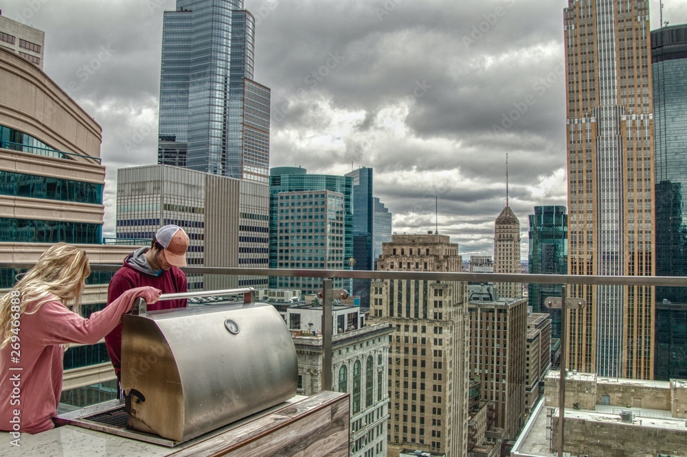 Young Couple relaxes and cooks on the rooftop Patio of a Downtown ...