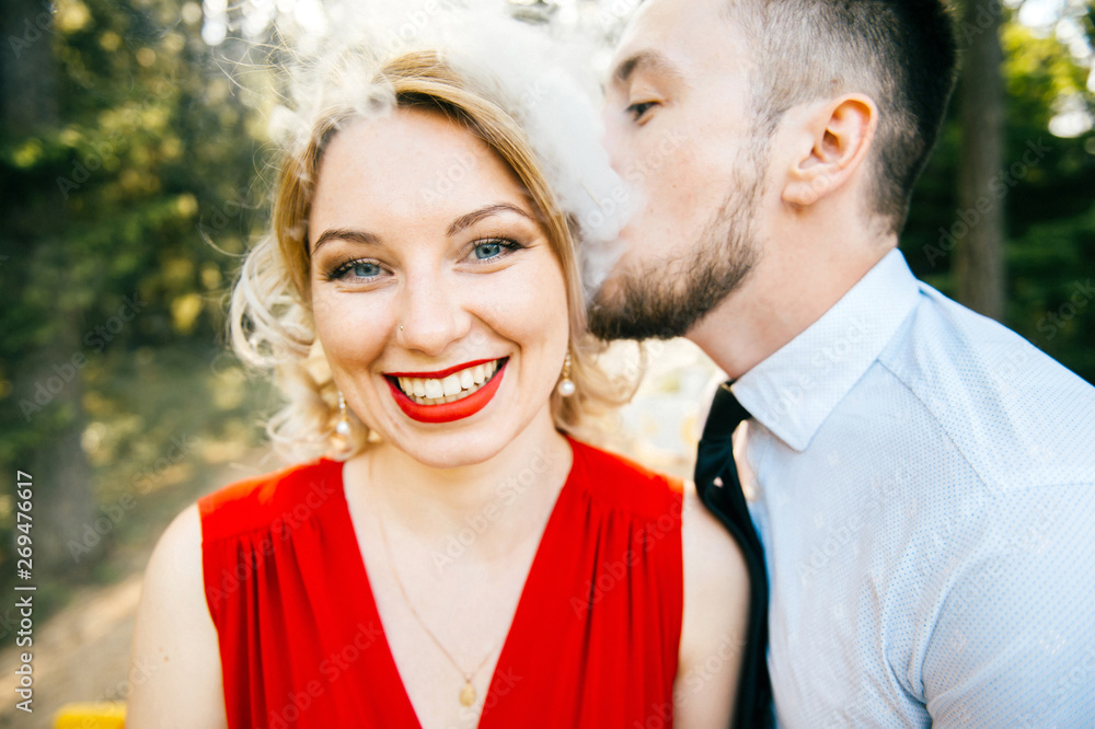 Odd excited happy loving couple outdoor summer portrait. Male vape ...