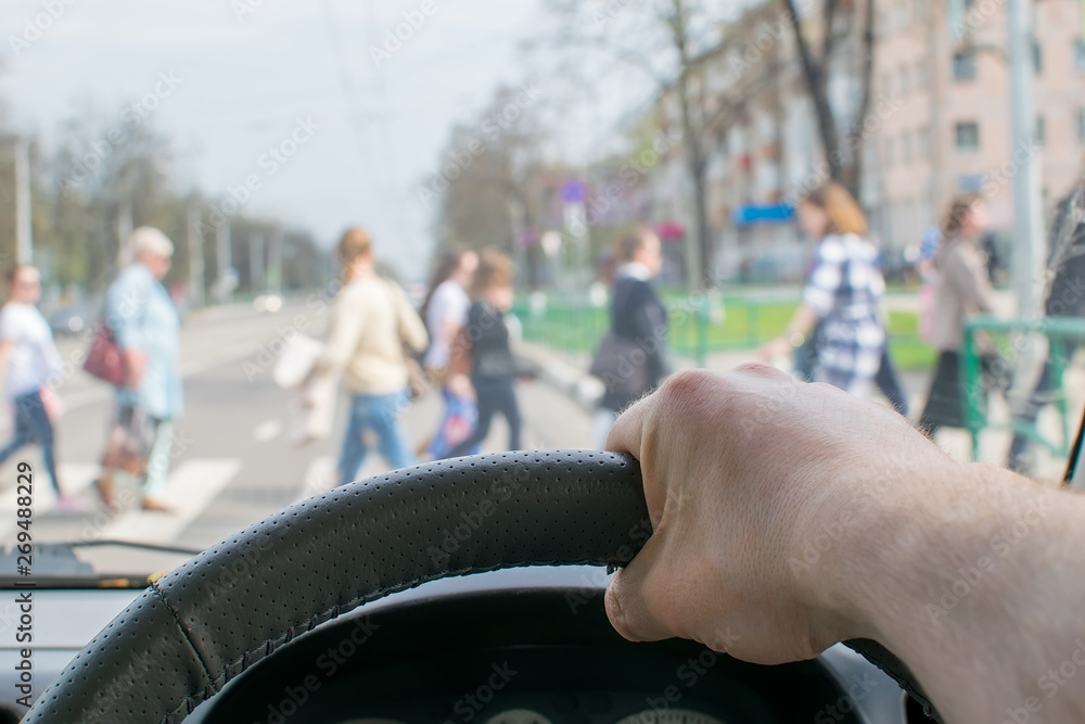 view from the car, the man's hand on the steering wheel of the car ...
