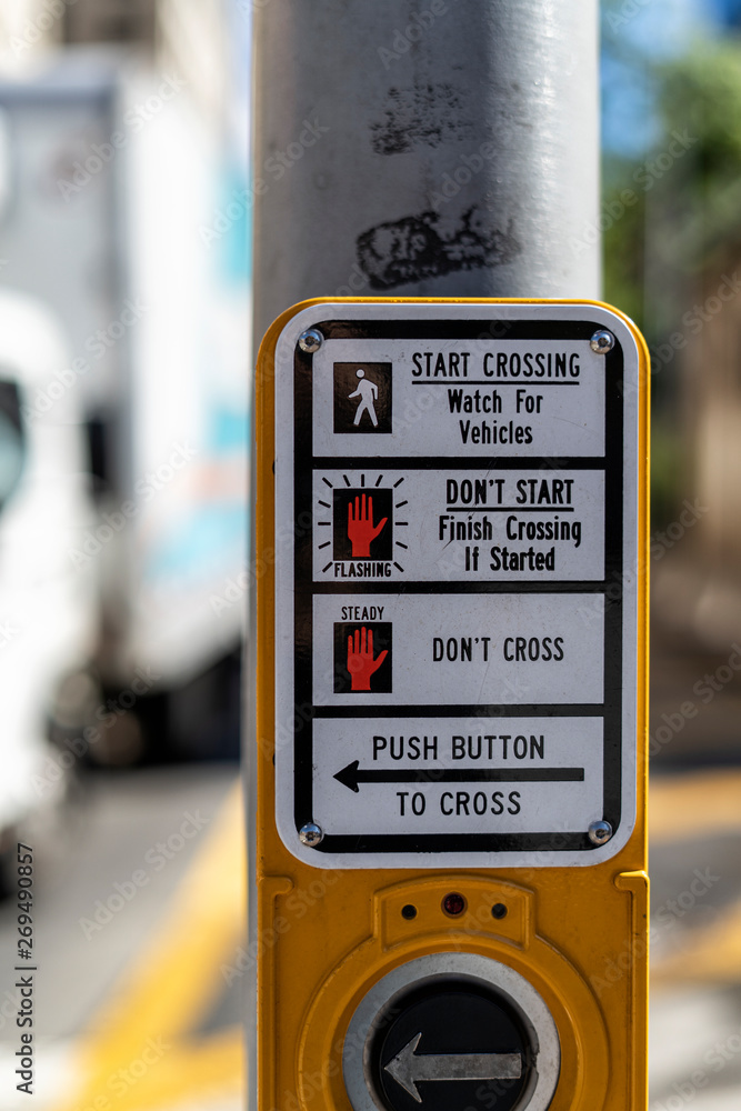 Push button to cross in New York CIty. Blurry background. warn out ...
