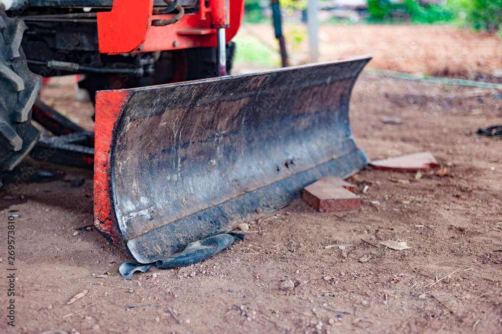 The grounding blade attached to the tractor is used to smooth the area ...