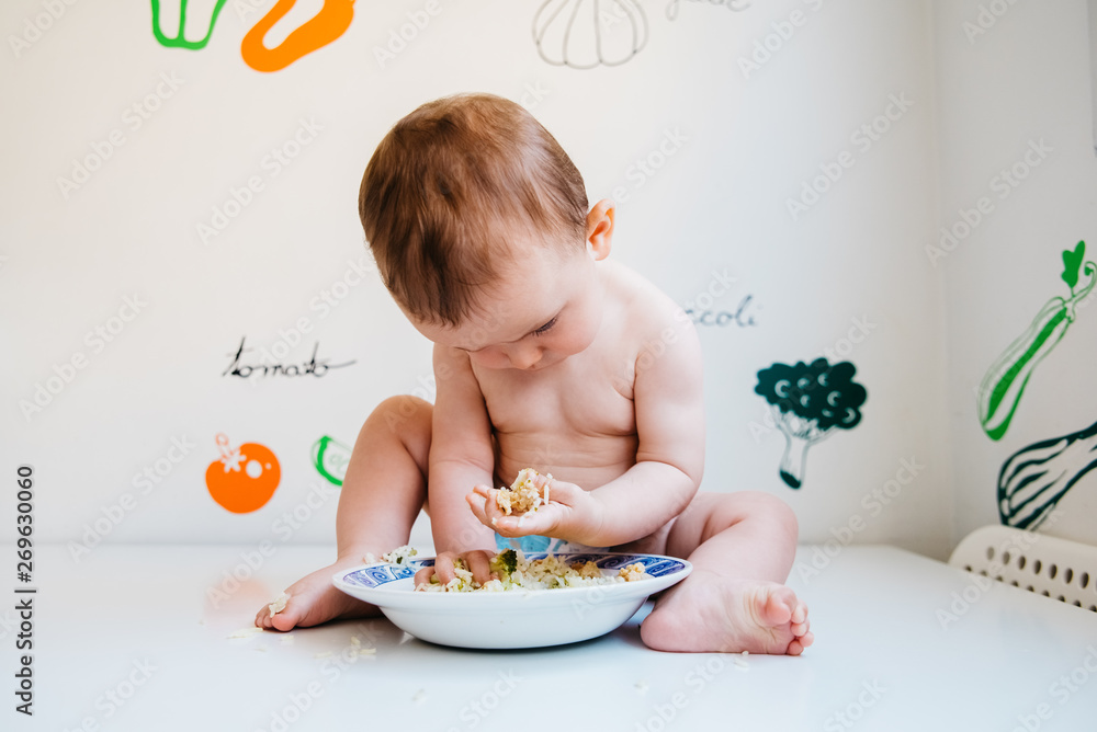 Baby eating by himself learning through the Baby-led Weaning method ...