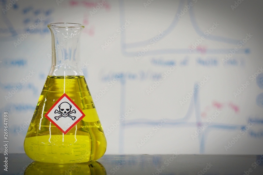 Erlenmeyer flask with Yellow liquid and chemical hazard warning symbols ...