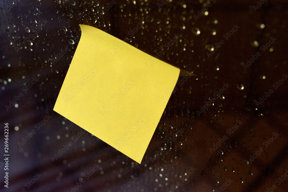 Piece of square sheet use to give notation stick to dewy wet glass ...