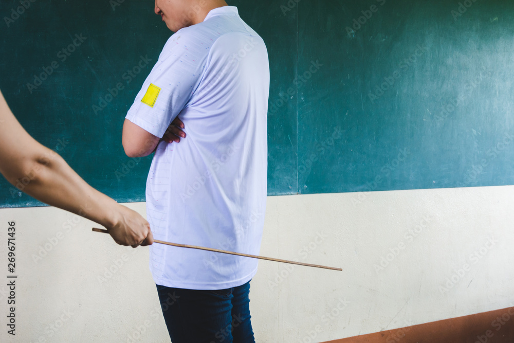 Students being physically punished by teacher with small wooden stick ...