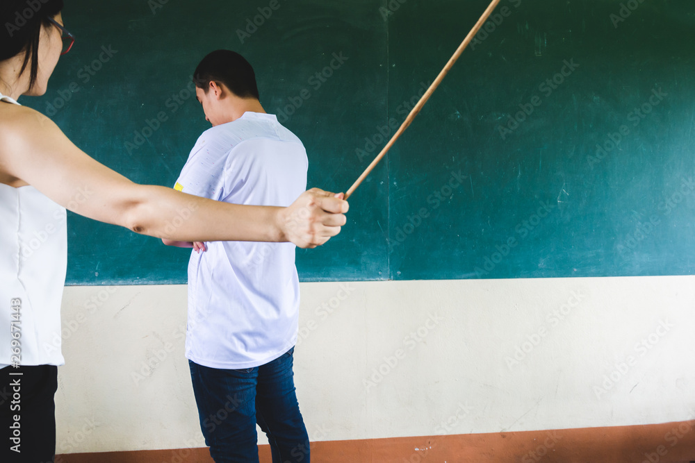 Students being physically punished by teacher with small wooden stick ...
